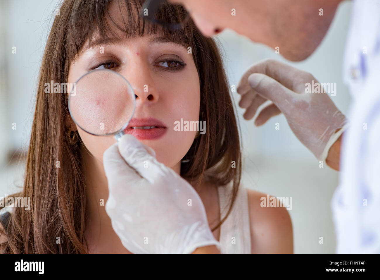 Doctor examining the skin of female patient Stock Photo - Alamy