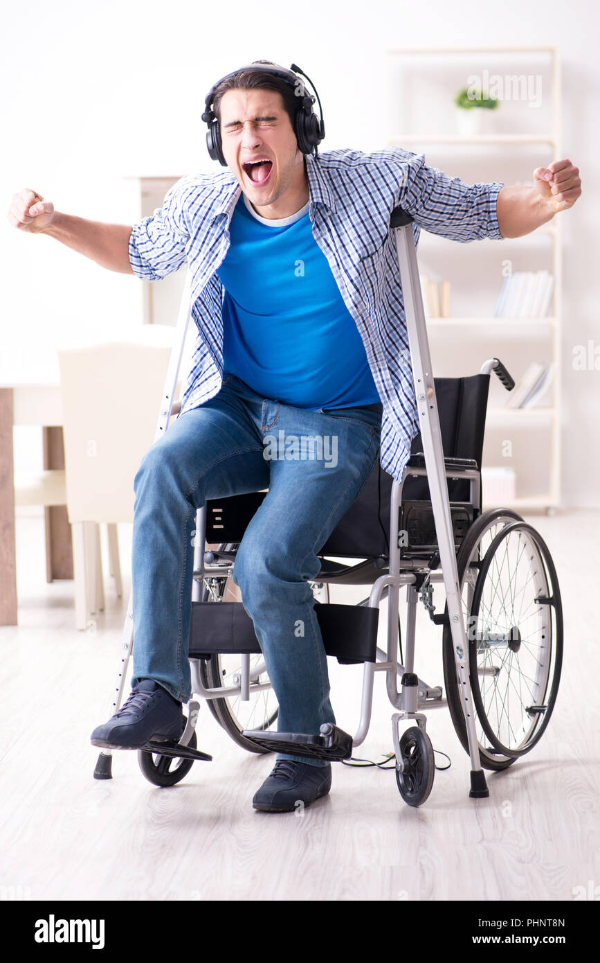 Disabled man listening to music in wheelchair Stock Photo - Alamy