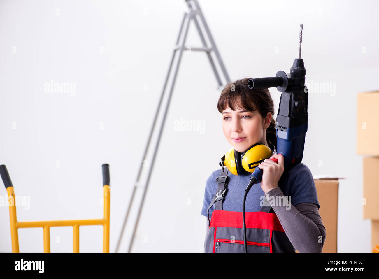 Woman contractor with hand drill at construction site Stock Photo - Alamy