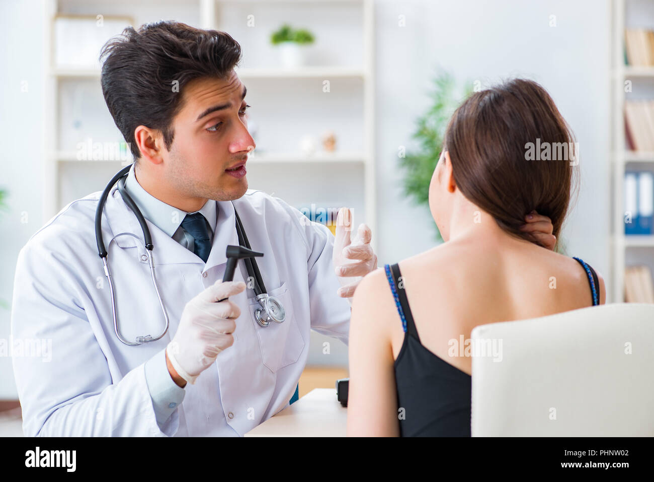 Doctor checking patients ear during medical examination Stock Photo - Alamy