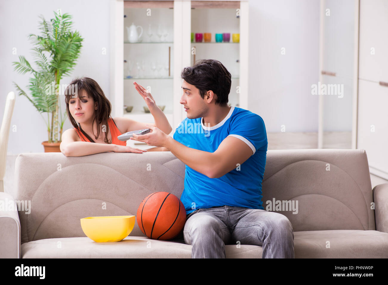 Man watching basketball with his wife Stock Photo - Alamy