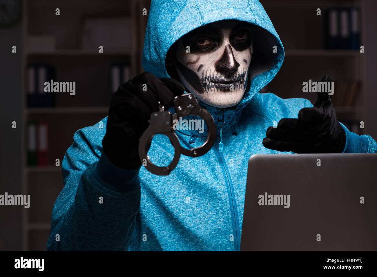Scary hacker hacking security firewall late in office Stock Photo - Alamy