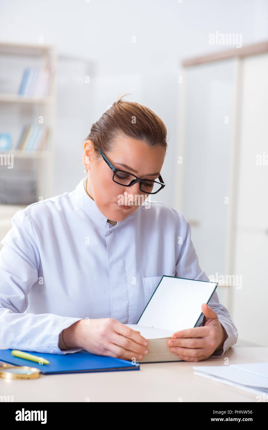 Woman doctor reading book Stock Photo - Alamy