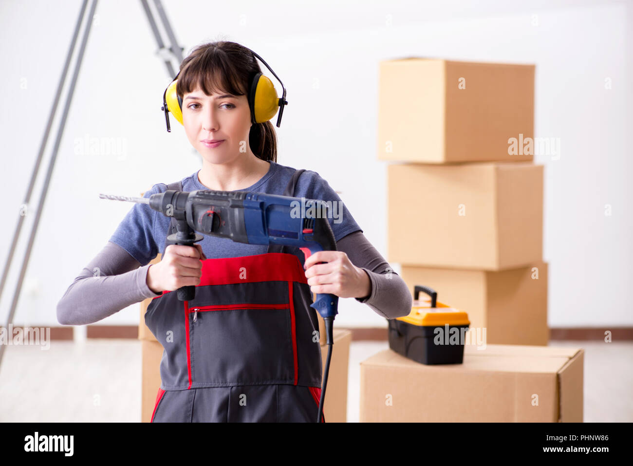 Woman contractor with hand drill at construction site Stock Photo - Alamy
