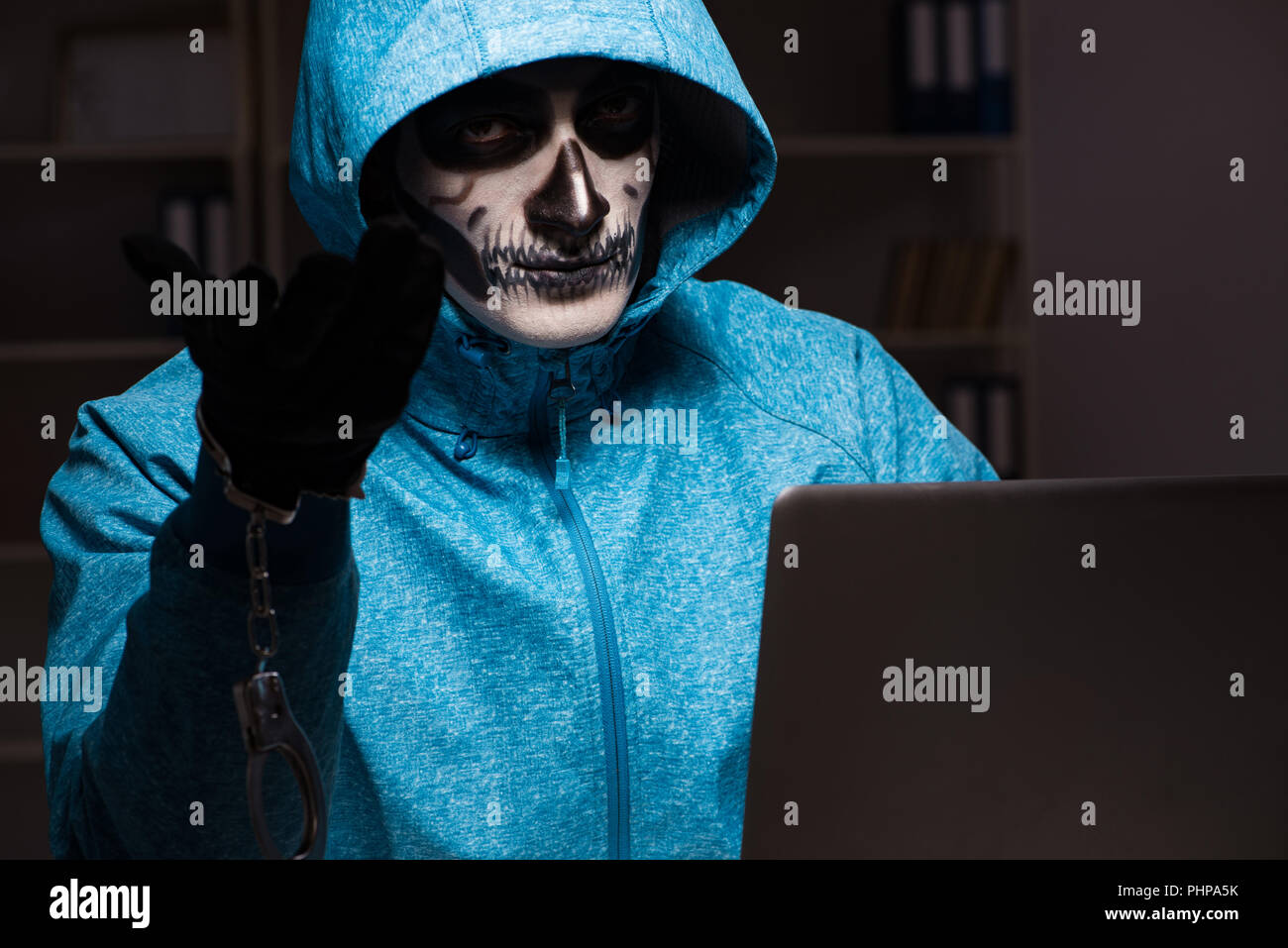 Scary hacker hacking security firewall late in office Stock Photo - Alamy