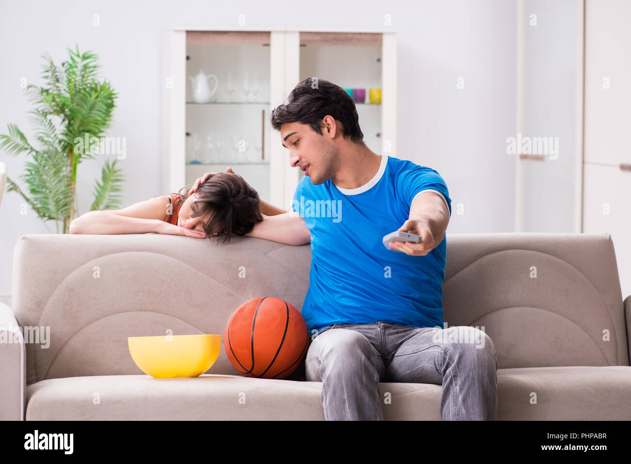 Man watching basketball with his wife Stock Photo - Alamy
