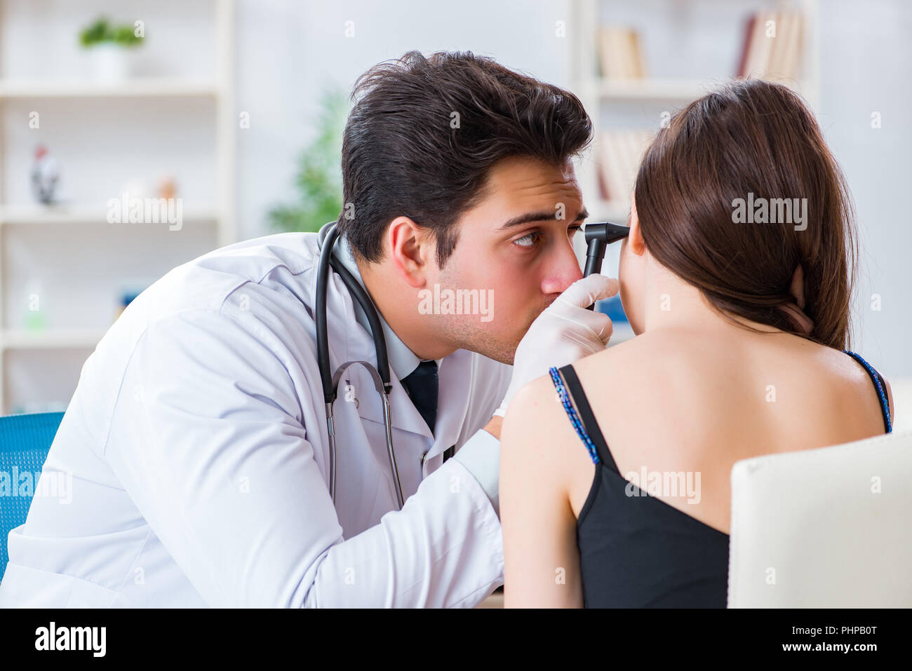 Doctor checking patients ear during medical examination Stock Photo - Alamy