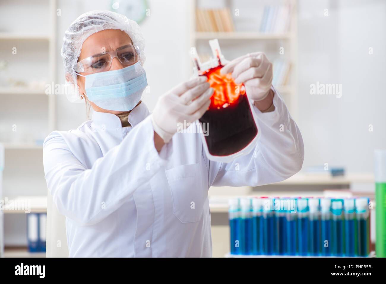 Woman doctor checking blood samples in lab Stock Photo - Alamy