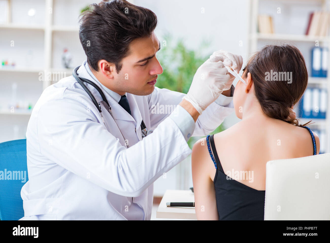 Doctor checking patients ear during medical examination Stock Photo - Alamy