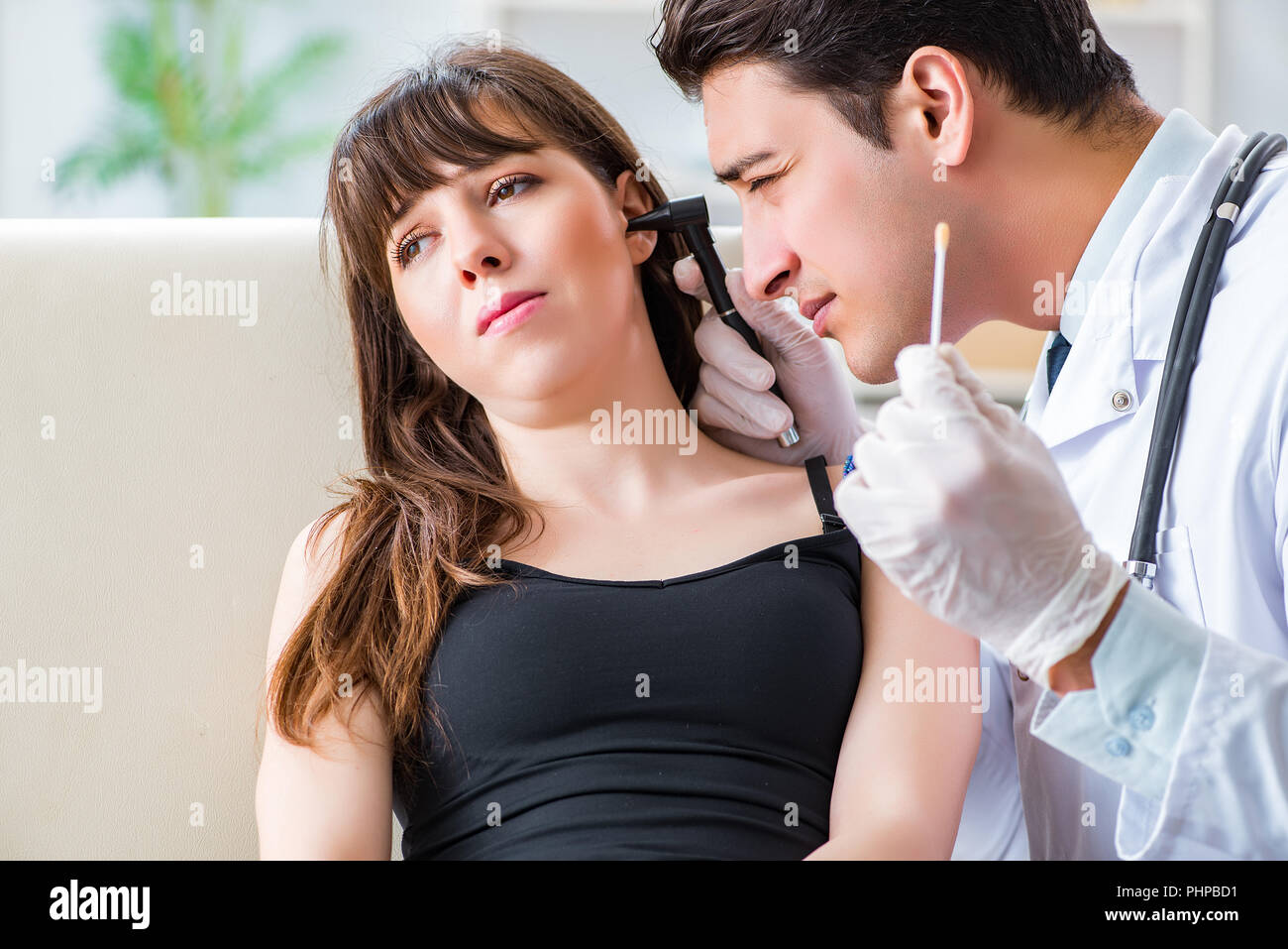 Doctor checking patients ear during medical examination Stock Photo - Alamy