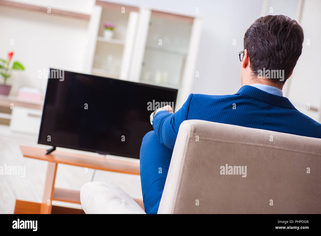 Businesman watching tv in office Stock Photo - Alamy