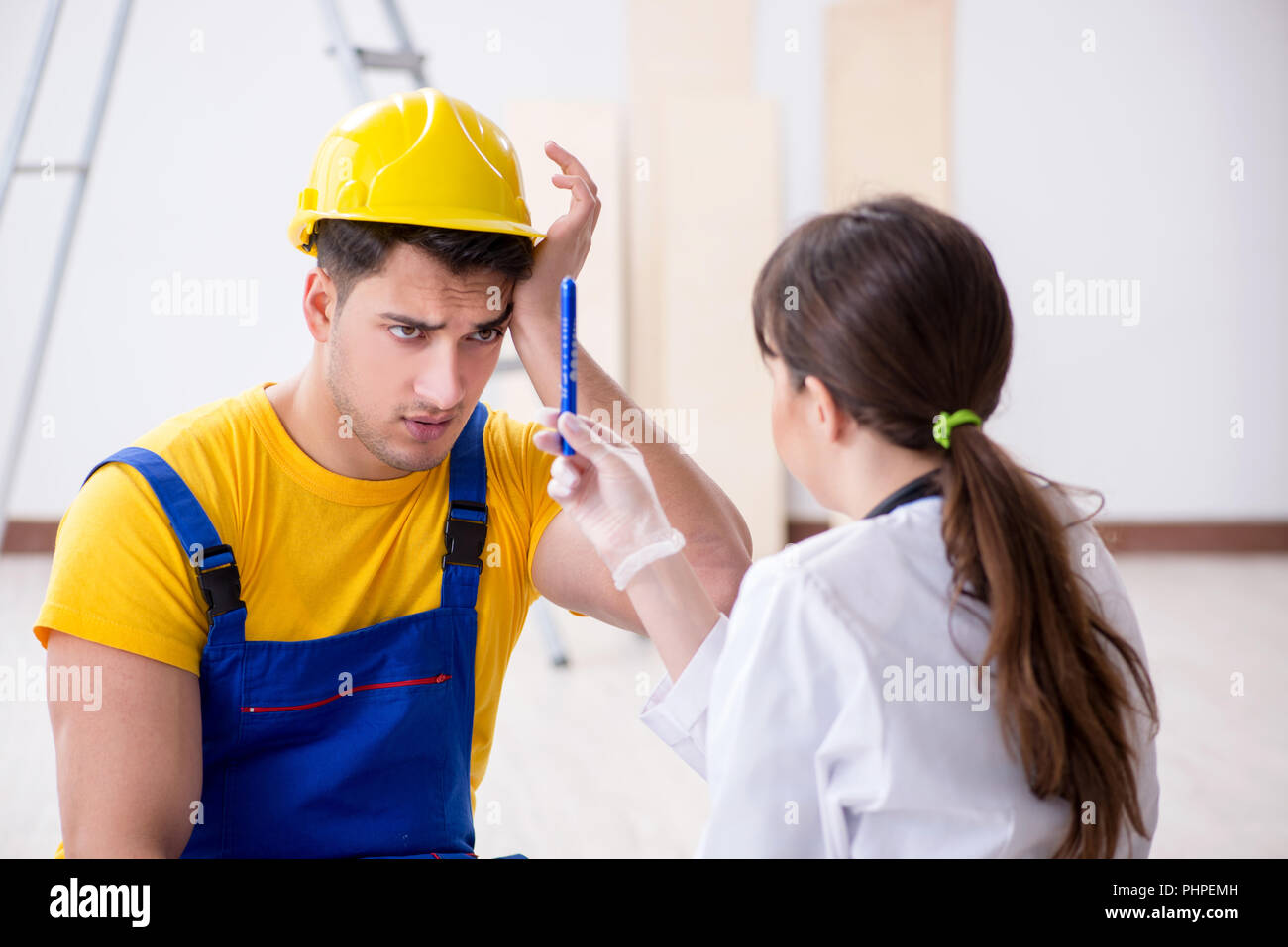 Doctor helping injured worker at construction site Stock Photo - Alamy