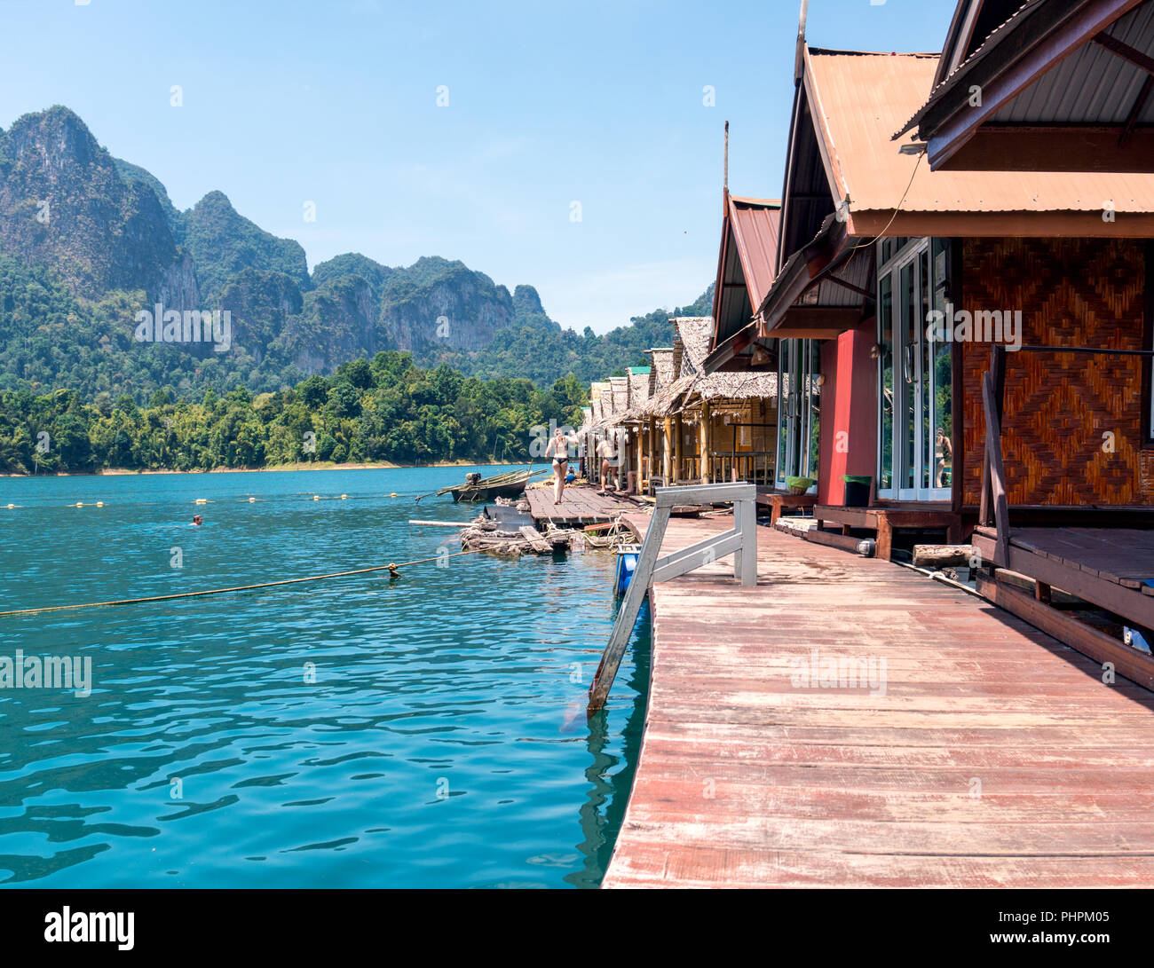 Floating wooden houses on a lake with mountains and rain forest in the ...