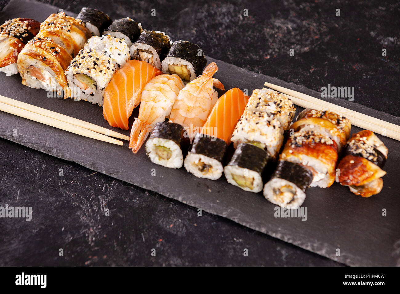 Variety mix of different types of sushi on dark stone background Stock ...