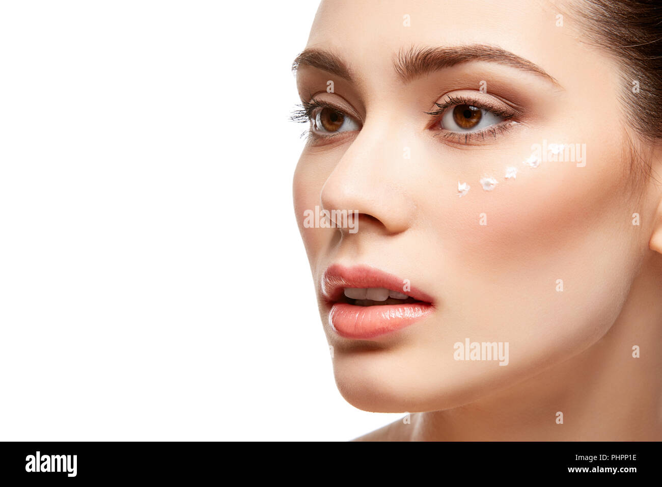 beautiful young woman with moisturizing skin cream dots on face. studio ...