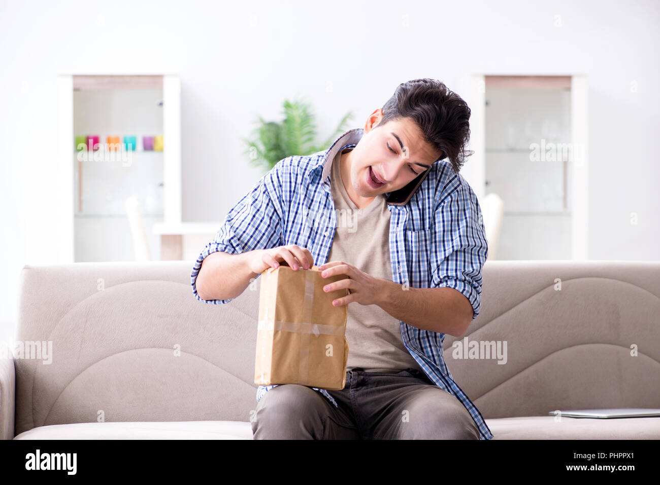 Man receiving parcel at home Stock Photo - Alamy