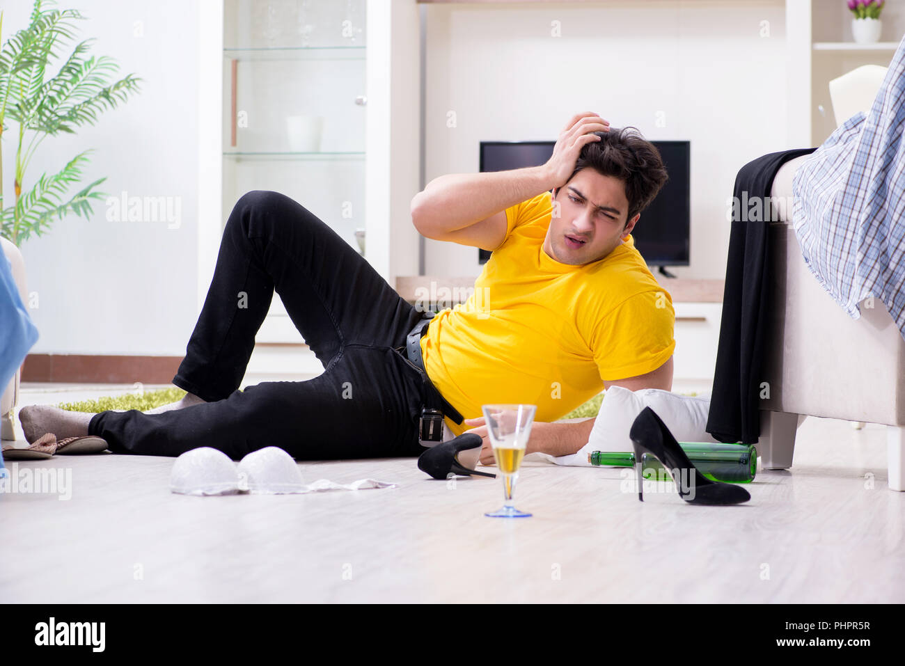 Man with mess at home after house party Stock Photo - Alamy