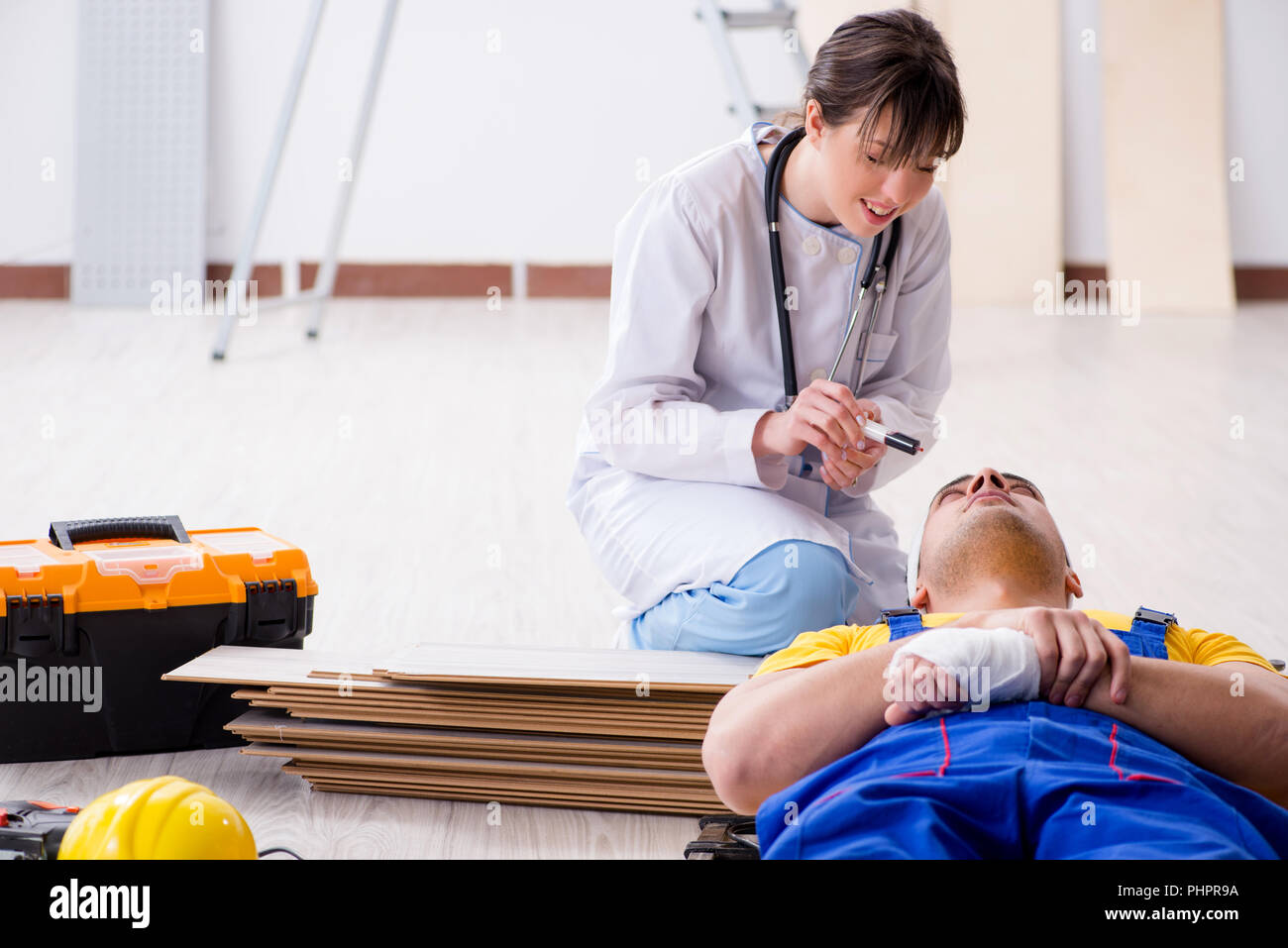 Doctor helping injured worker at construction site Stock Photo - Alamy