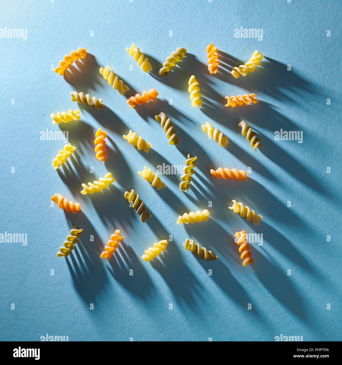 Multi-colored spiral pasta isolated on blue background. Flat lay Stock ...