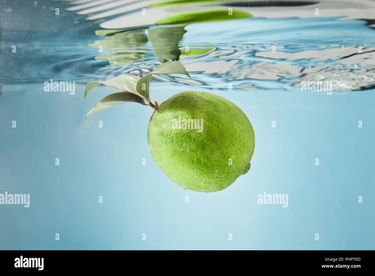 Lime falls into the water creating splashes on the water Stock Photo ...