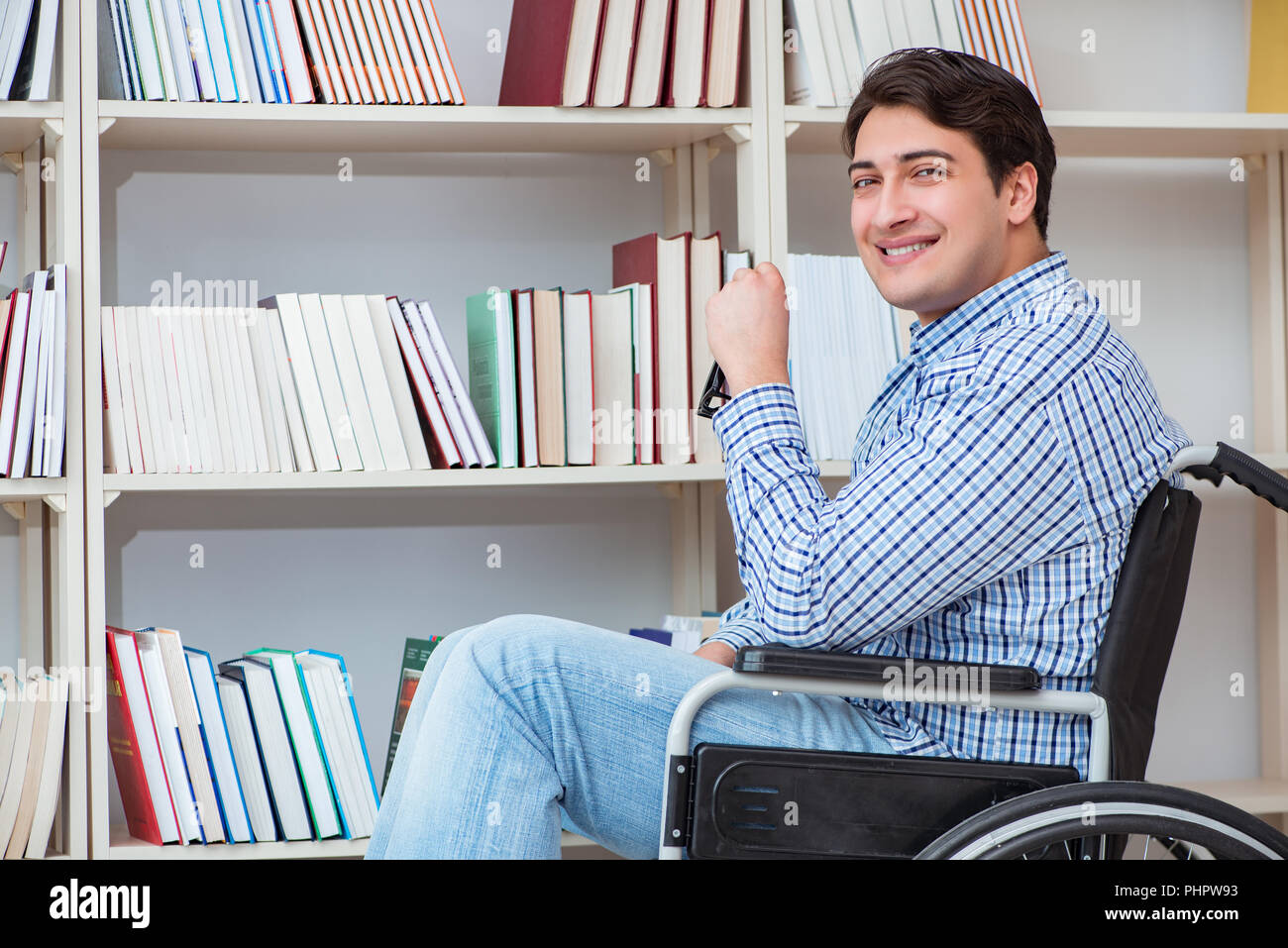 Disabled student studying in the library Stock Photo - Alamy