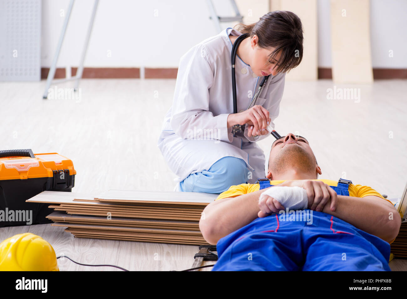 Doctor helping injured worker at construction site Stock Photo - Alamy