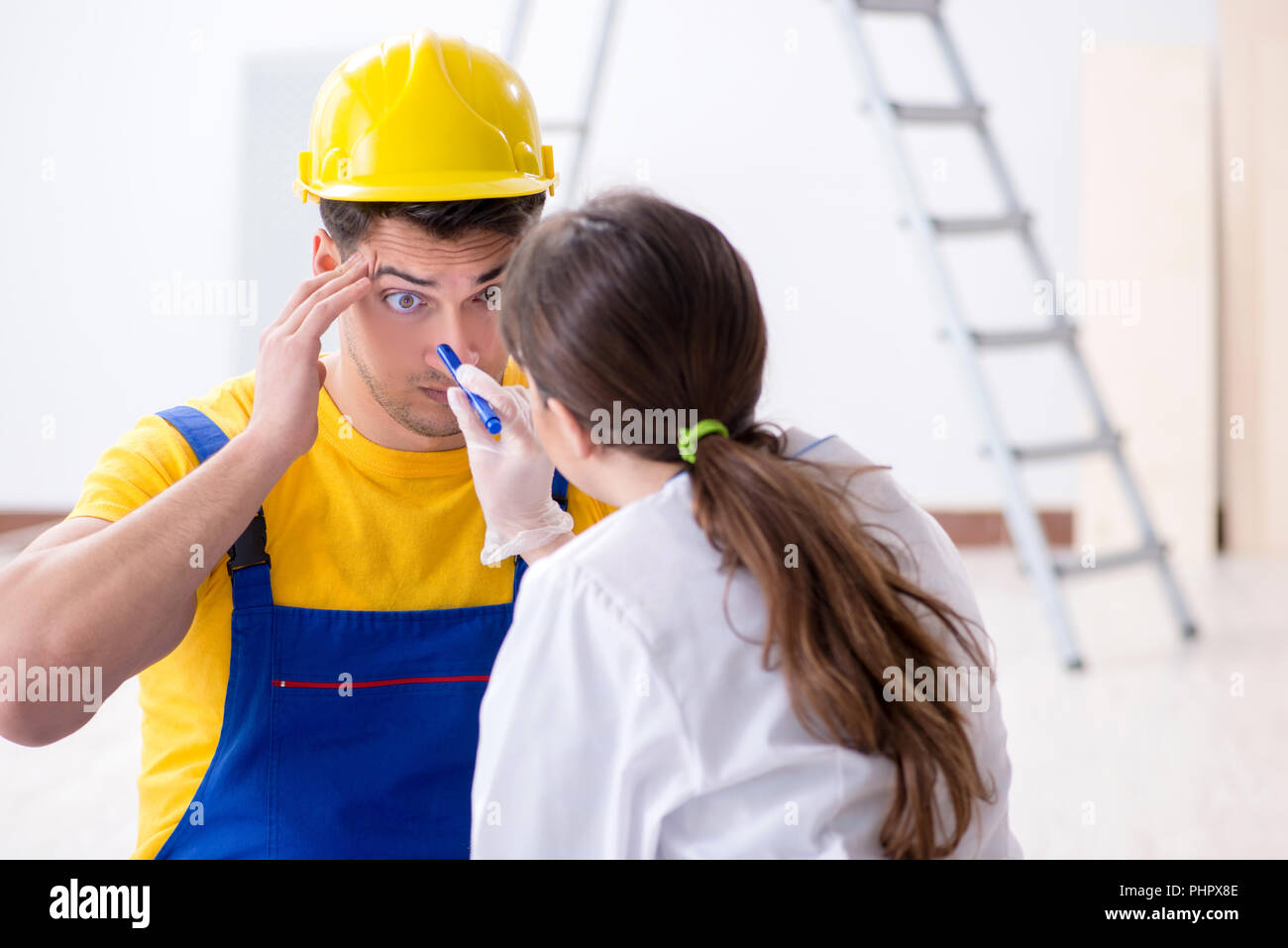 Doctor helping injured worker at construction site Stock Photo - Alamy