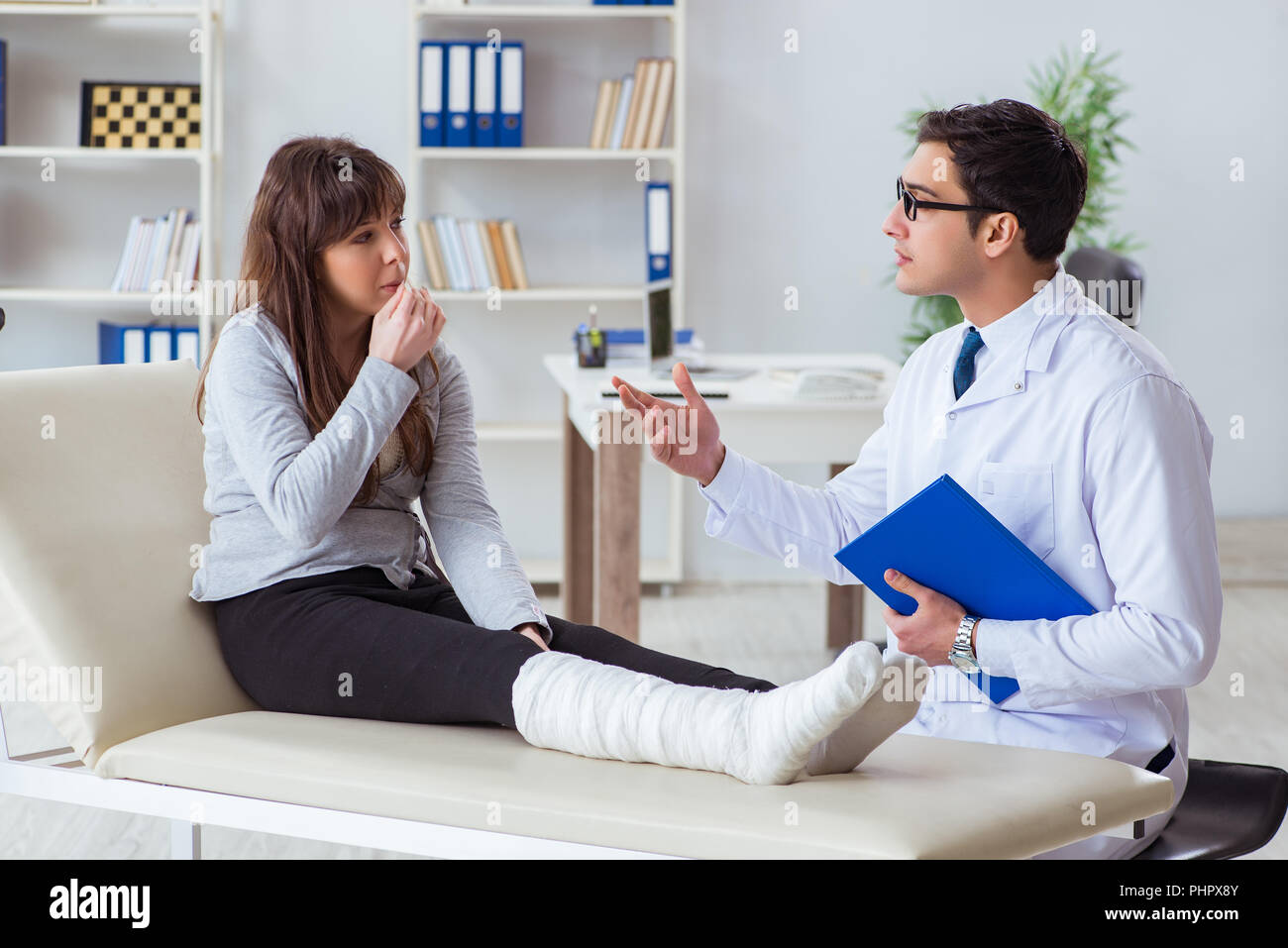 Doctor examining patient with broken leg Stock Photo - Alamy