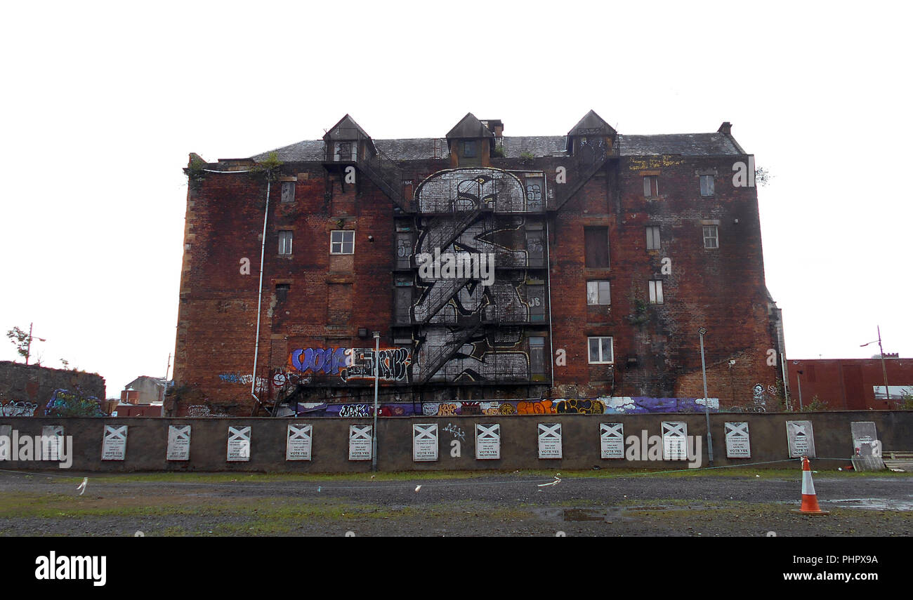 A huge empty, red brick abandoned, derelict and boarded up building on ...