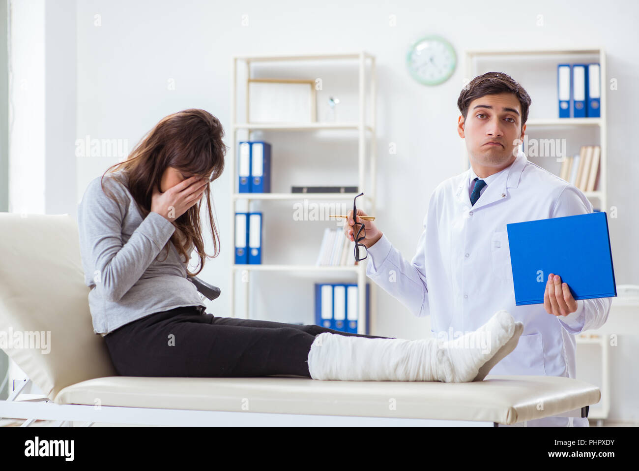 Doctor examining patient with broken leg Stock Photo - Alamy