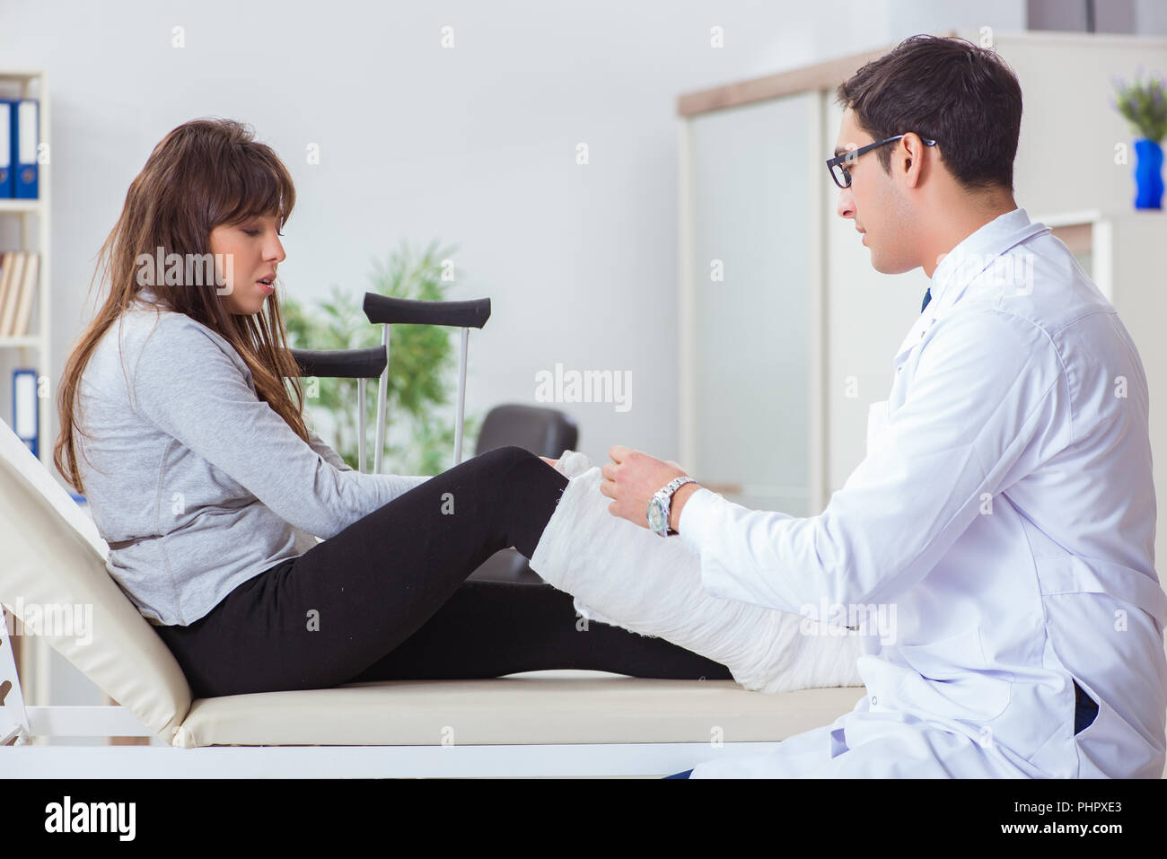 Doctor examining patient with broken leg Stock Photo - Alamy