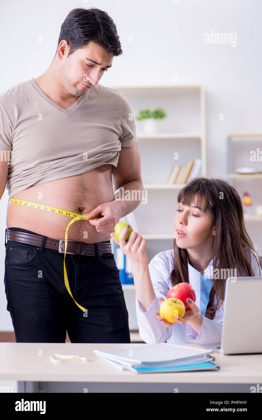 Doctor dietician giving advices to fat overweight patient Stock Photo ...