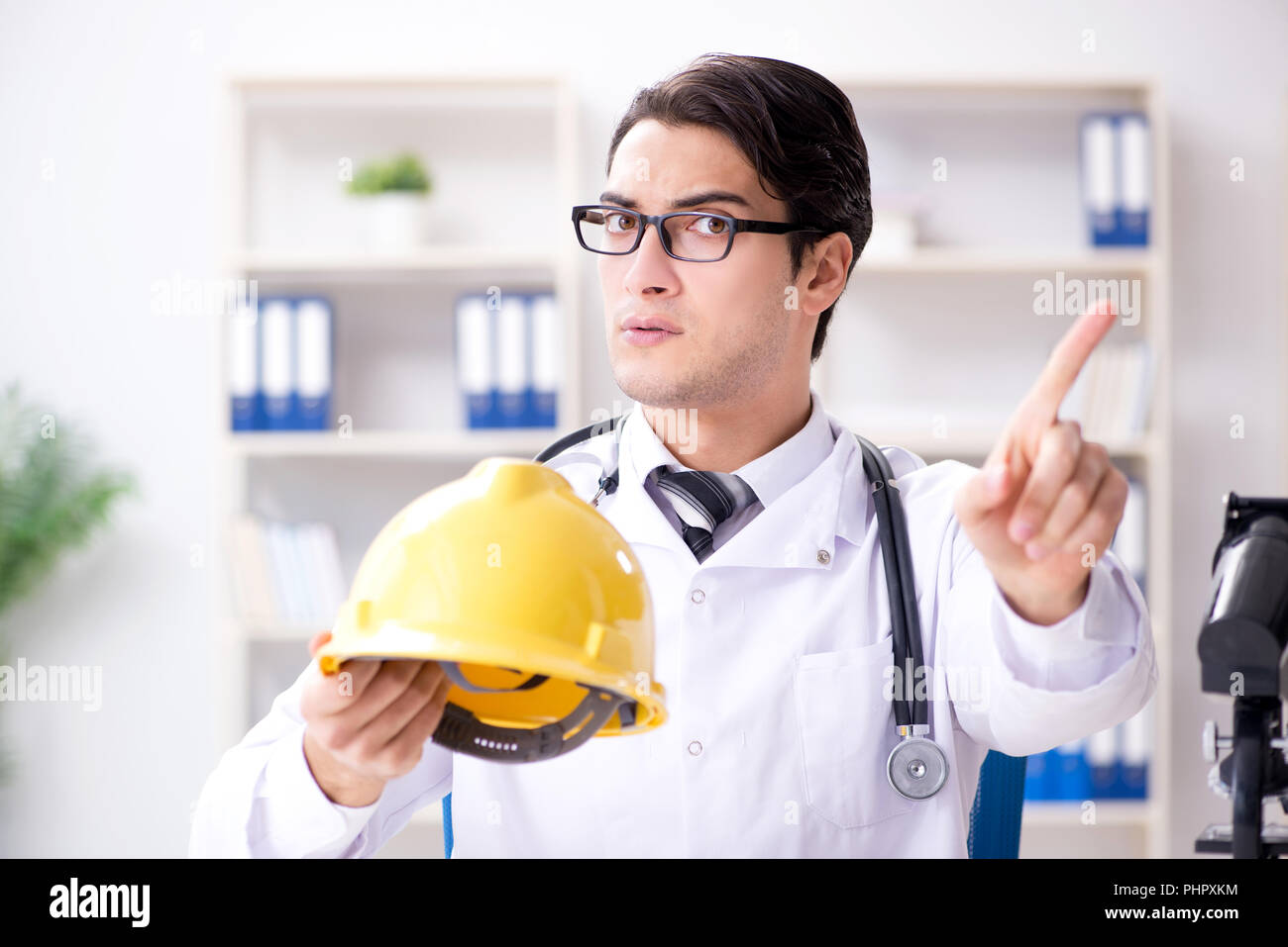 Safety doctor advising about wearing hard hat Stock Photo - Alamy