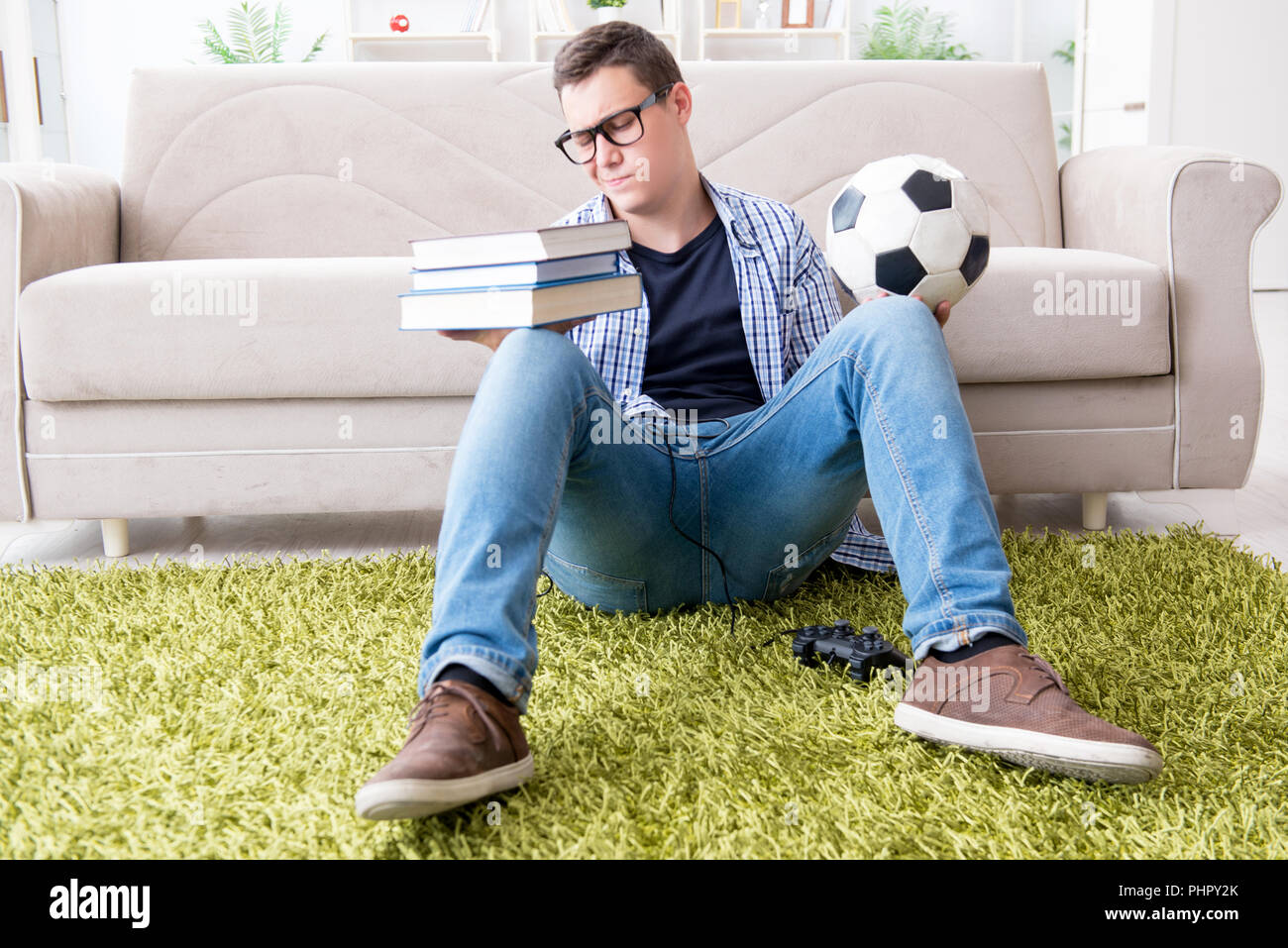 Young student trying to balance studying and playing football Stock ...