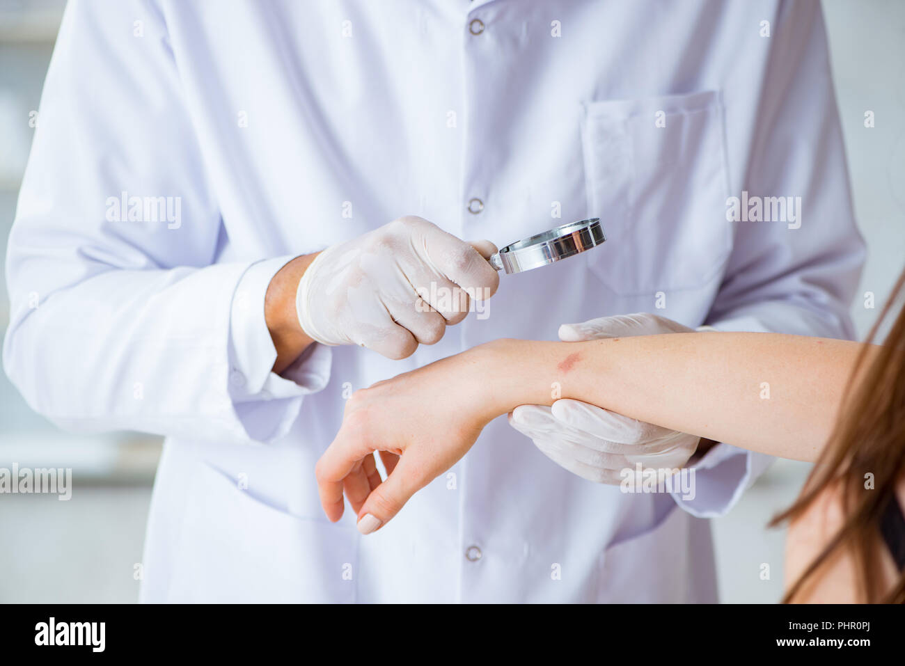 Doctor examining the skin of female patient Stock Photo - Alamy