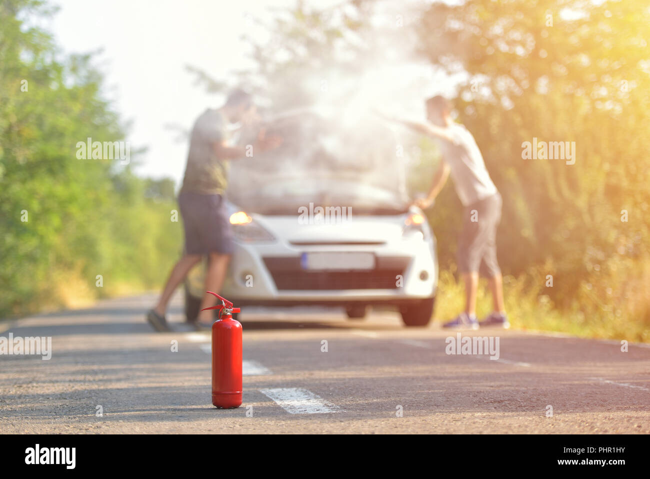 Fire extinguisher against car incident on the road with smoke on the ...