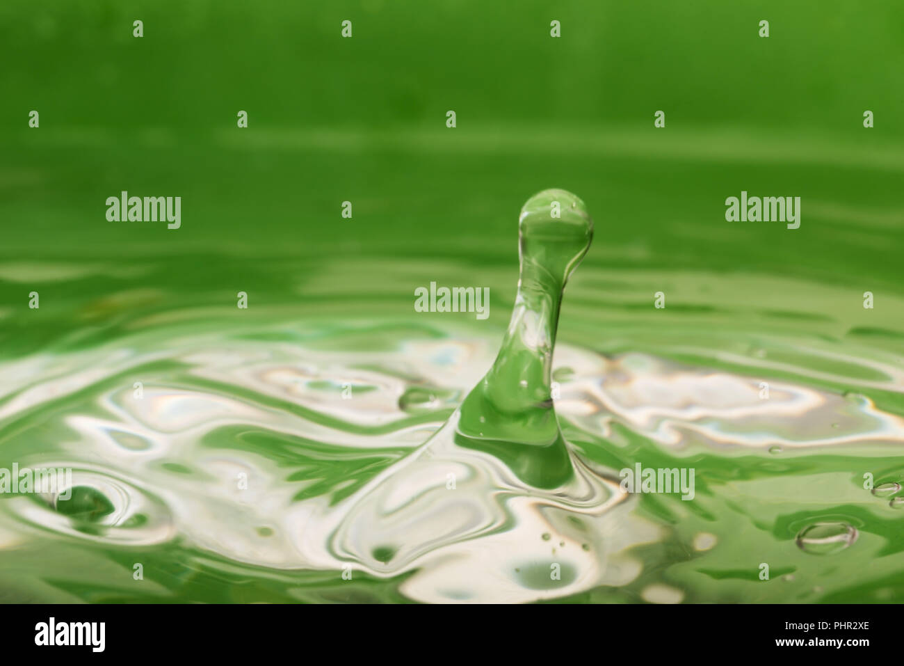 Water drop on a green background Stock Photo - Alamy