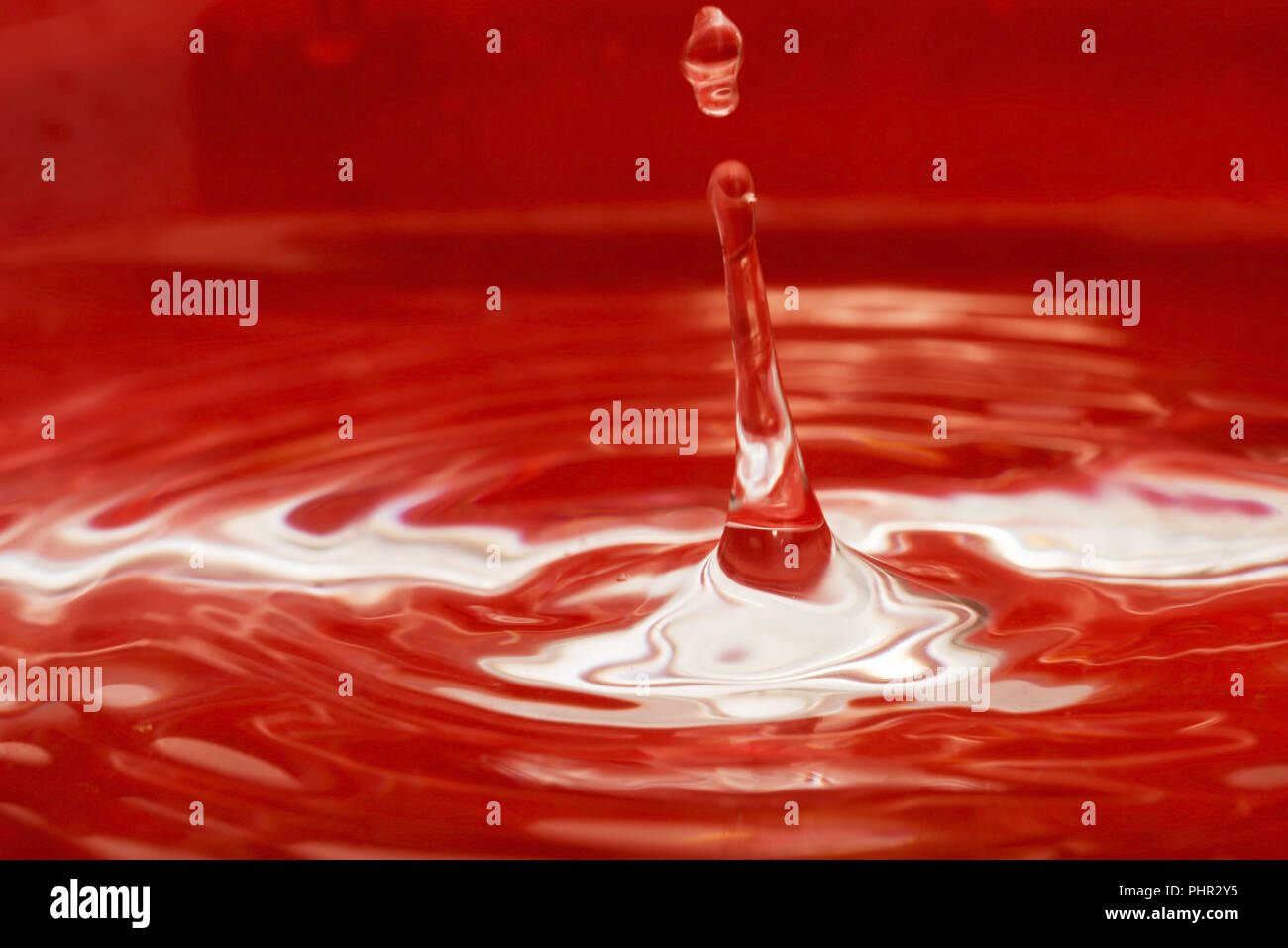 Water drop on a red background Stock Photo - Alamy