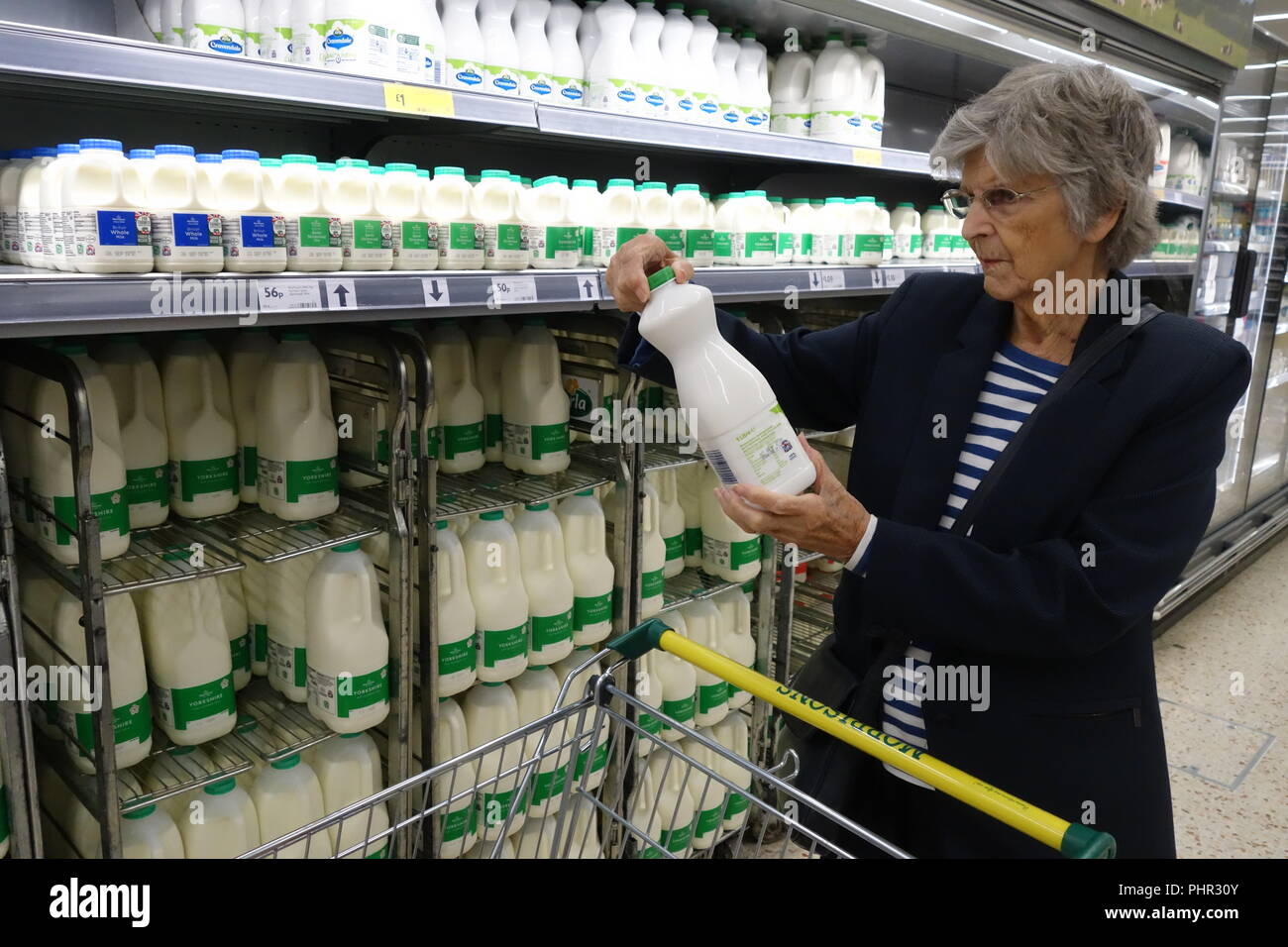 Elderly lady buying milk at her supermarket shopping at Morrisons ...