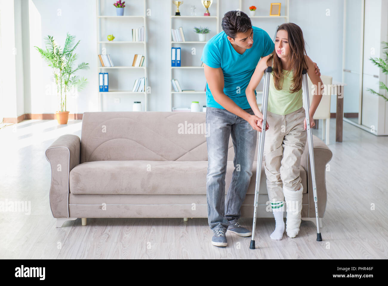 Husband man supporting injured wife Stock Photo - Alamy