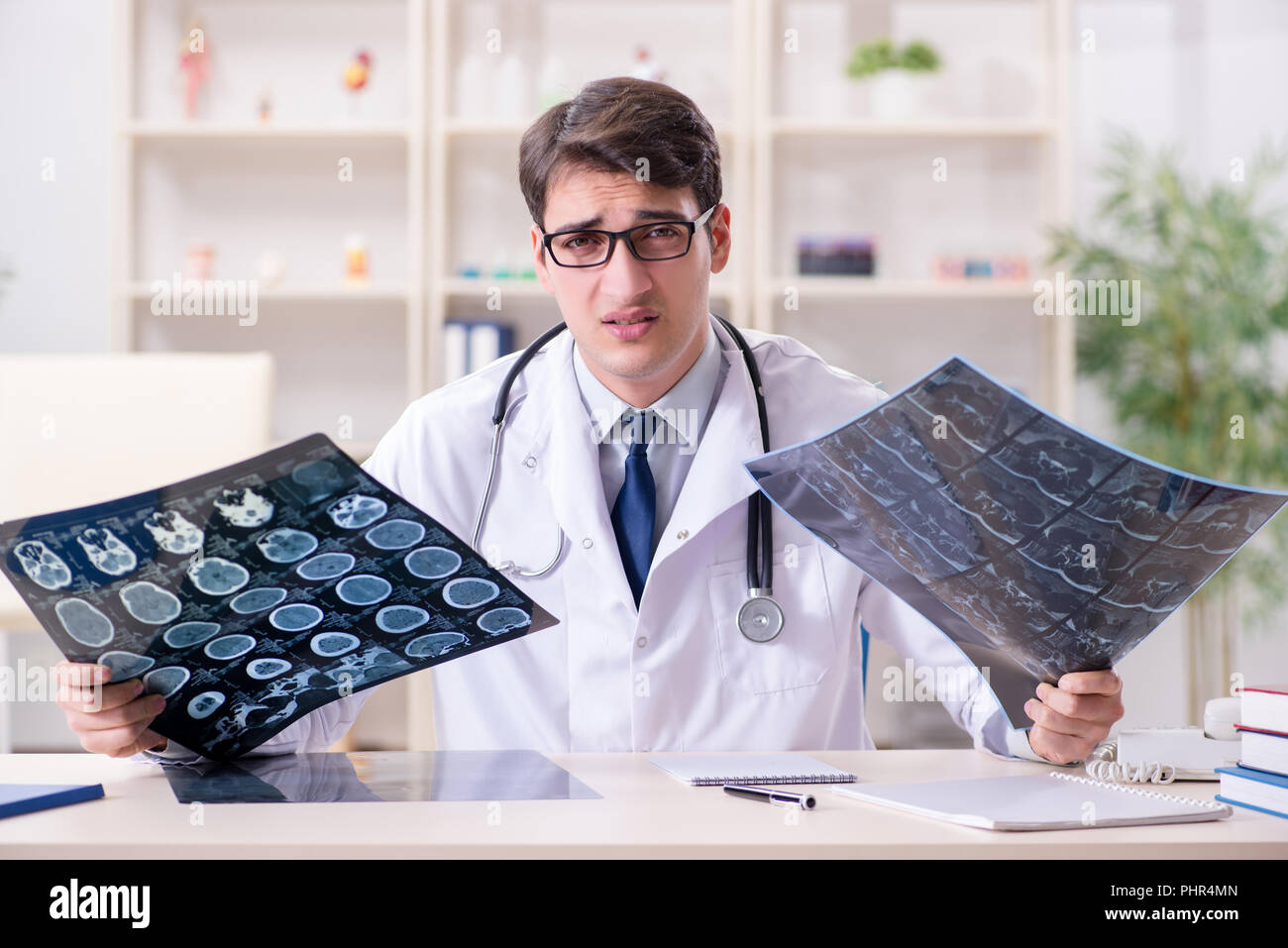 Young doctor looking at x-ray images in clinic Stock Photo - Alamy