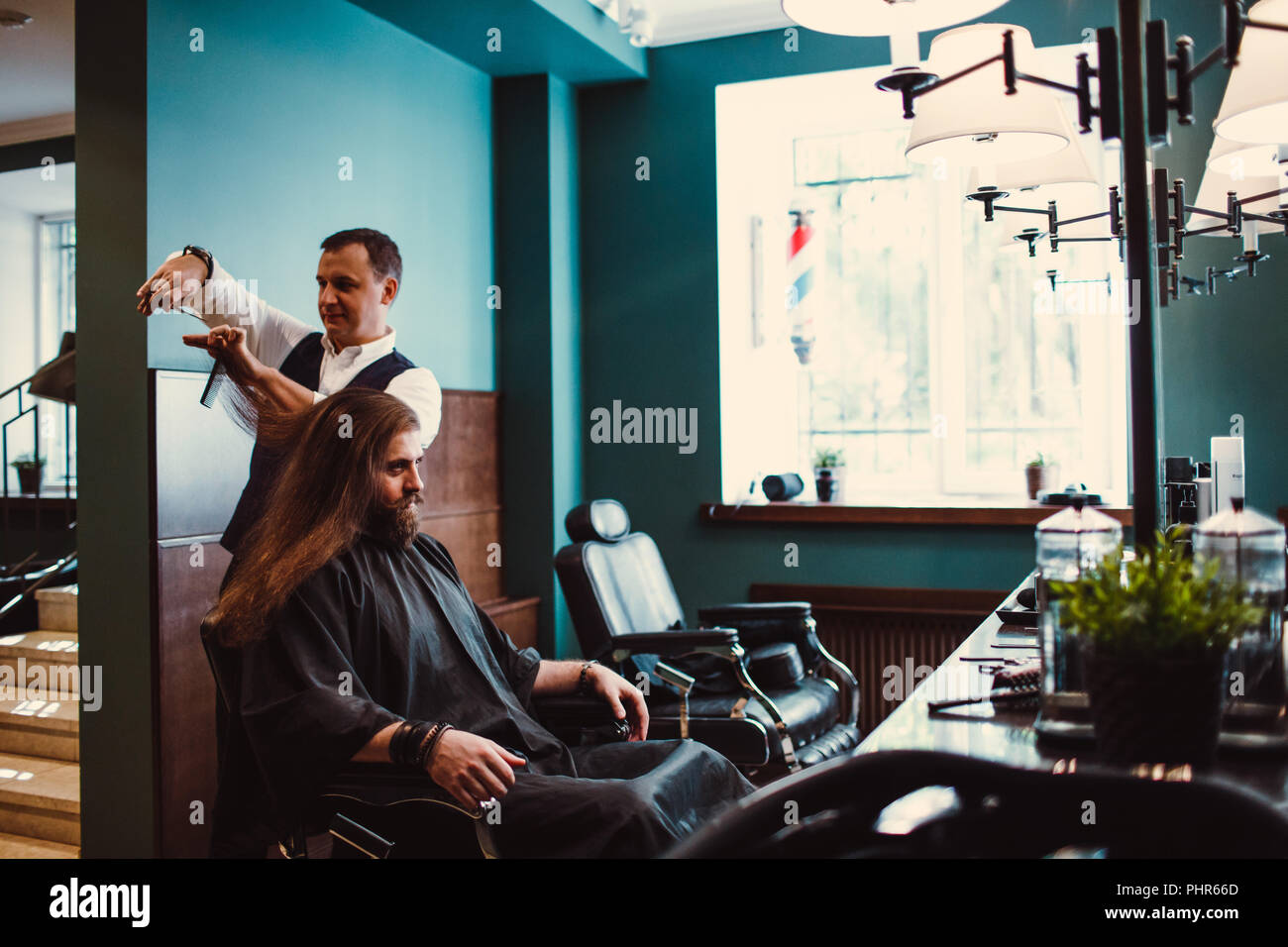 Barbershop with wooden interior. Bearded model man and barber Stock ...
