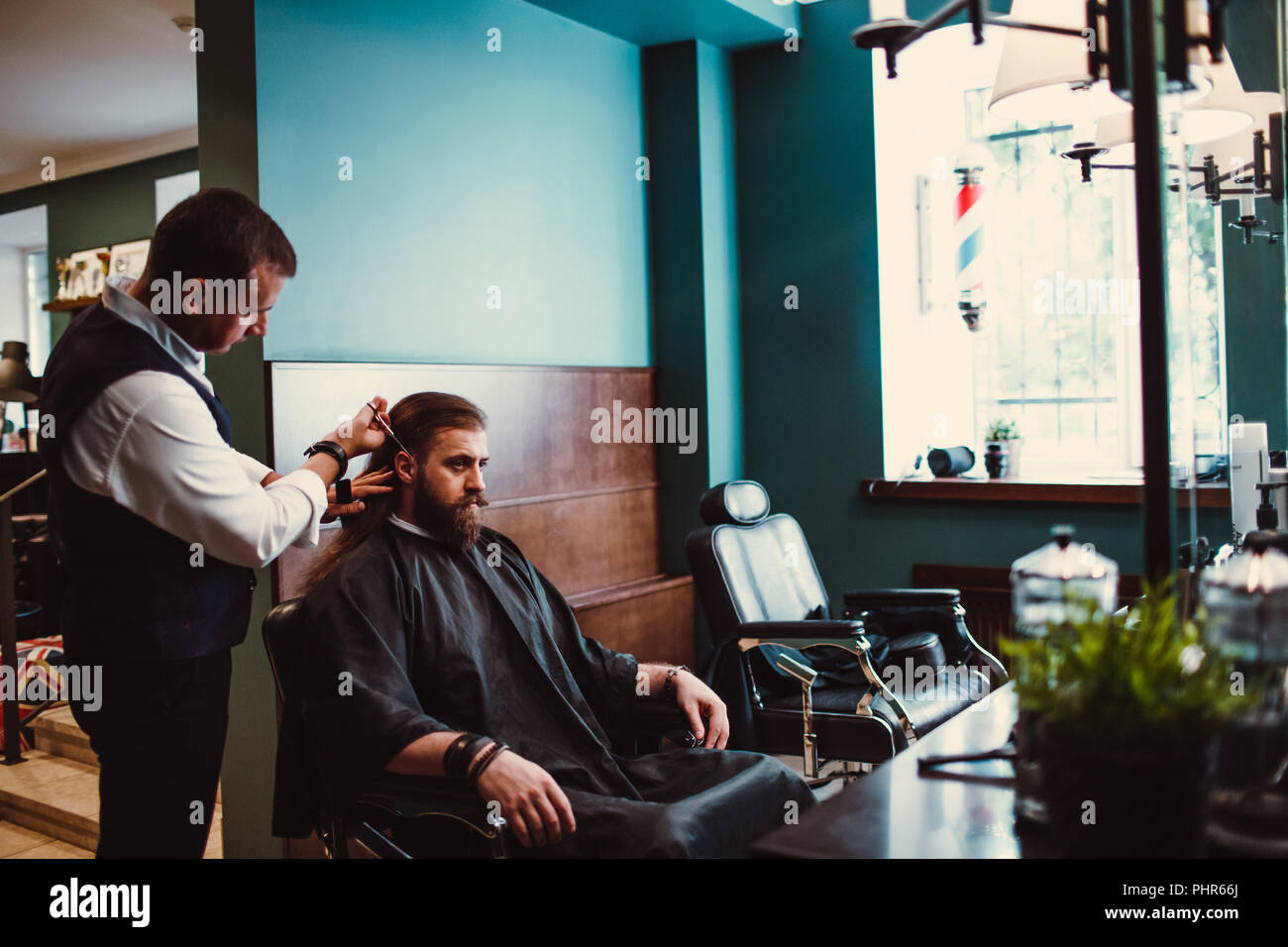 Barbershop with wooden interior. Bearded model man and barber Stock ...