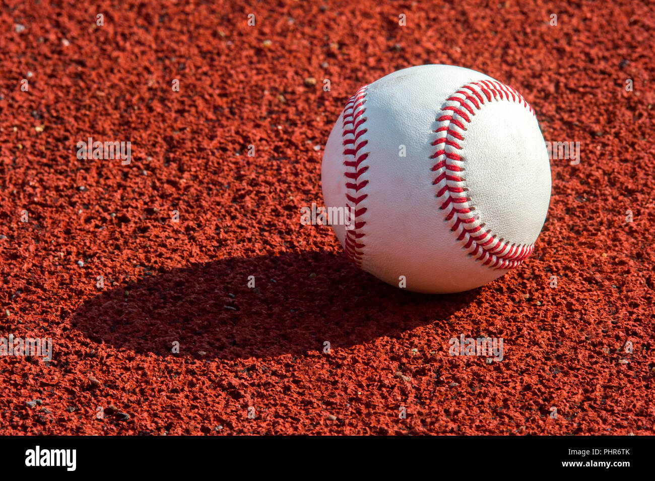 new baseball ball on red track rubber Stock Photo - Alamy