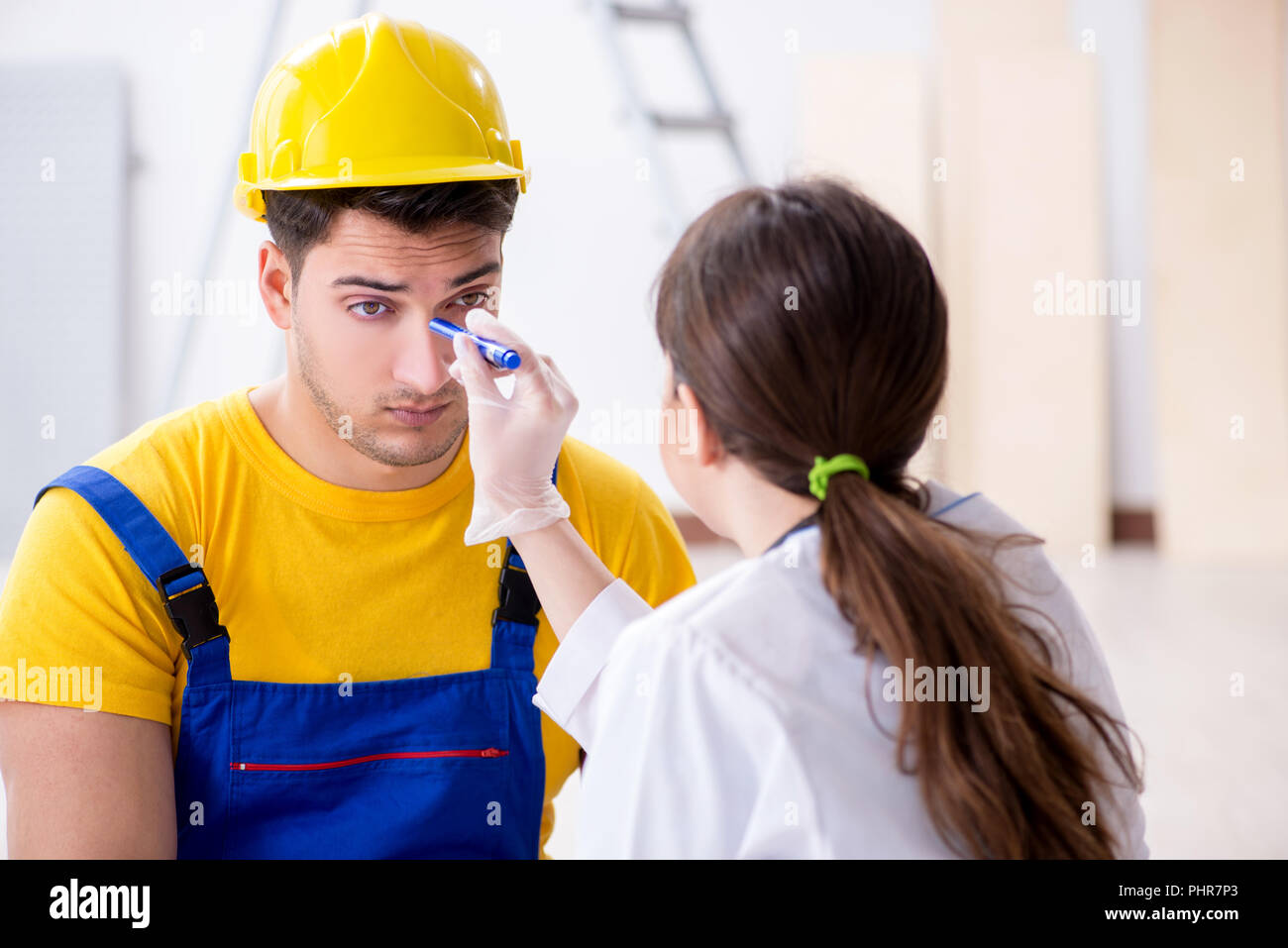Doctor helping injured worker at construction site Stock Photo - Alamy