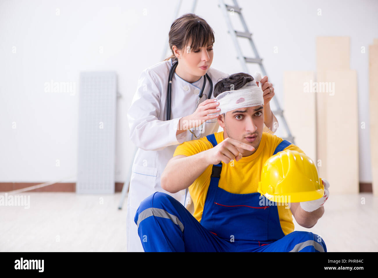 Worker with injured head and doctor Stock Photo - Alamy