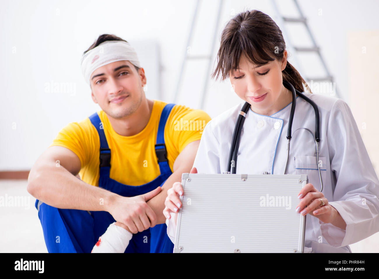 Worker with injured head and doctor Stock Photo - Alamy