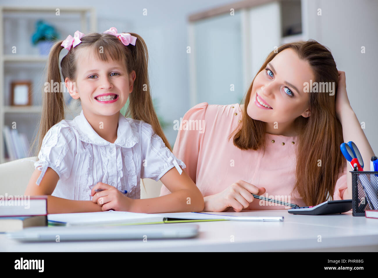 Mother helping her daughter to do homework Stock Photo - Alamy