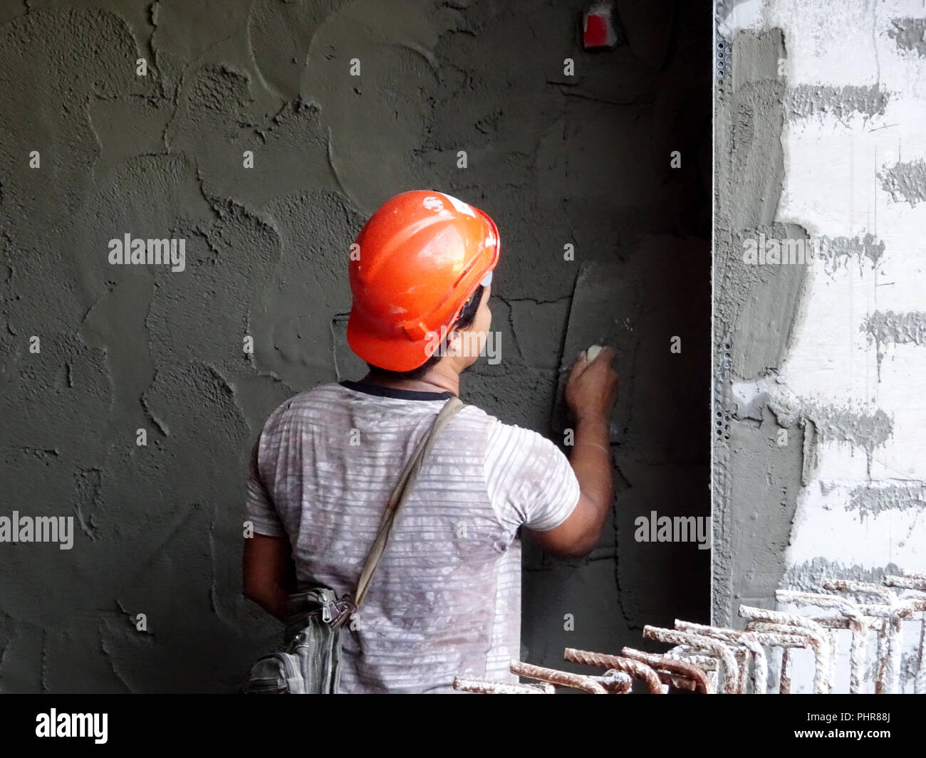 Construction workers plastering wall using cement plaster at the ...