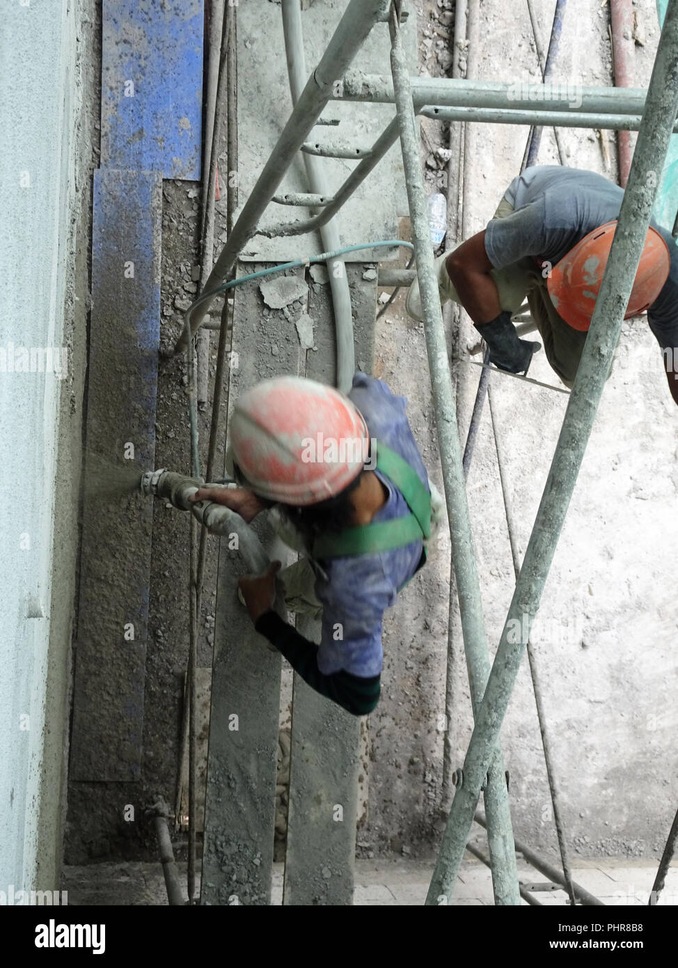Construction workers plastering wall using cement plaster at the ...